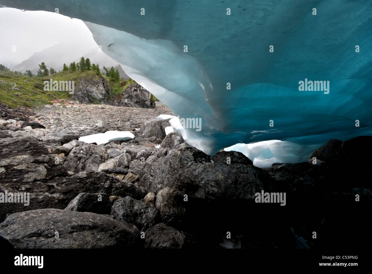 Blue wavy ice shape (glacier) against a valley in Sayan mountains. Wild ...