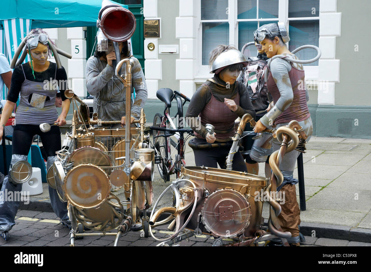 Musicians taking part in street theatre using improvised instruments ...