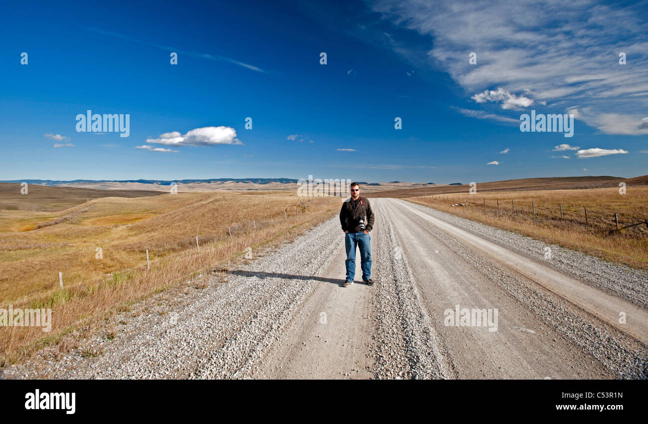 Man on the road with camera Stock Photo - Alamy