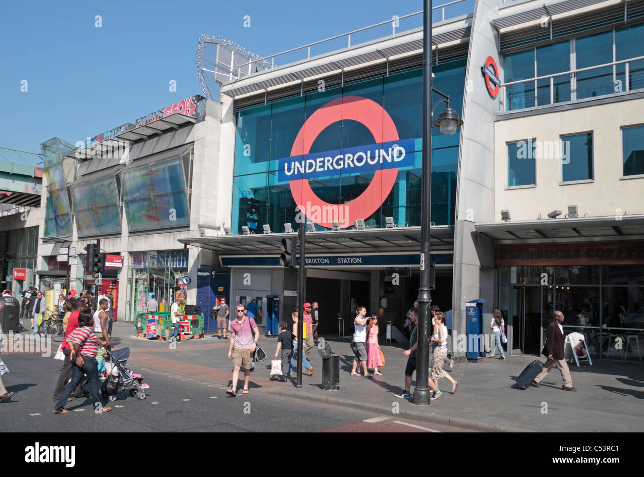 Pedestrians and passengers outside Brixton Underground station, London ...
