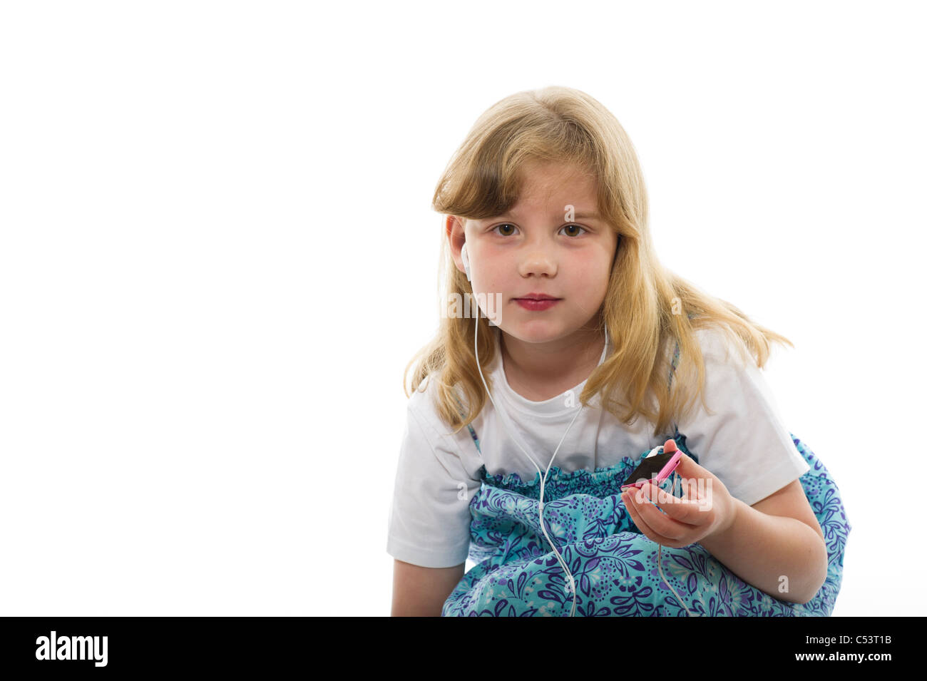 A young girl of 7 or 8 years listening to an ipod Nano/MP3 player ...