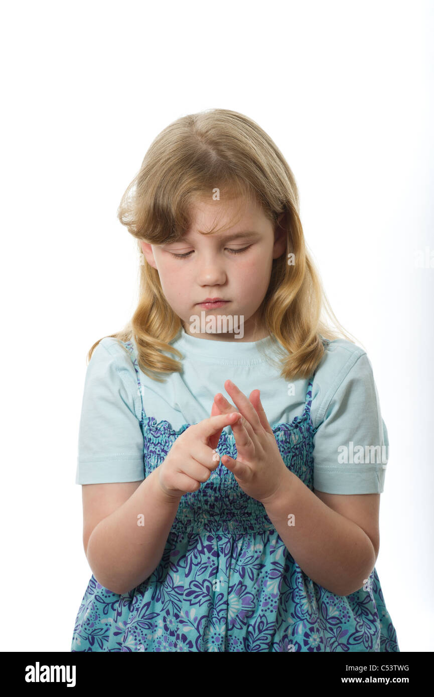 A young primary age girl doing addition by counting on her fingers ...