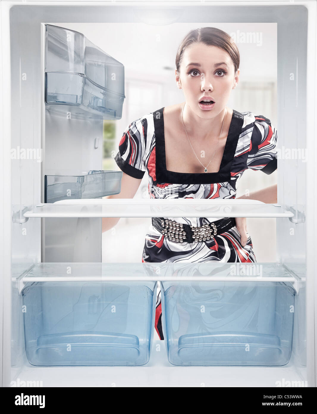 Young woman looking on empty shelf in fridge Stock Photo - Alamy