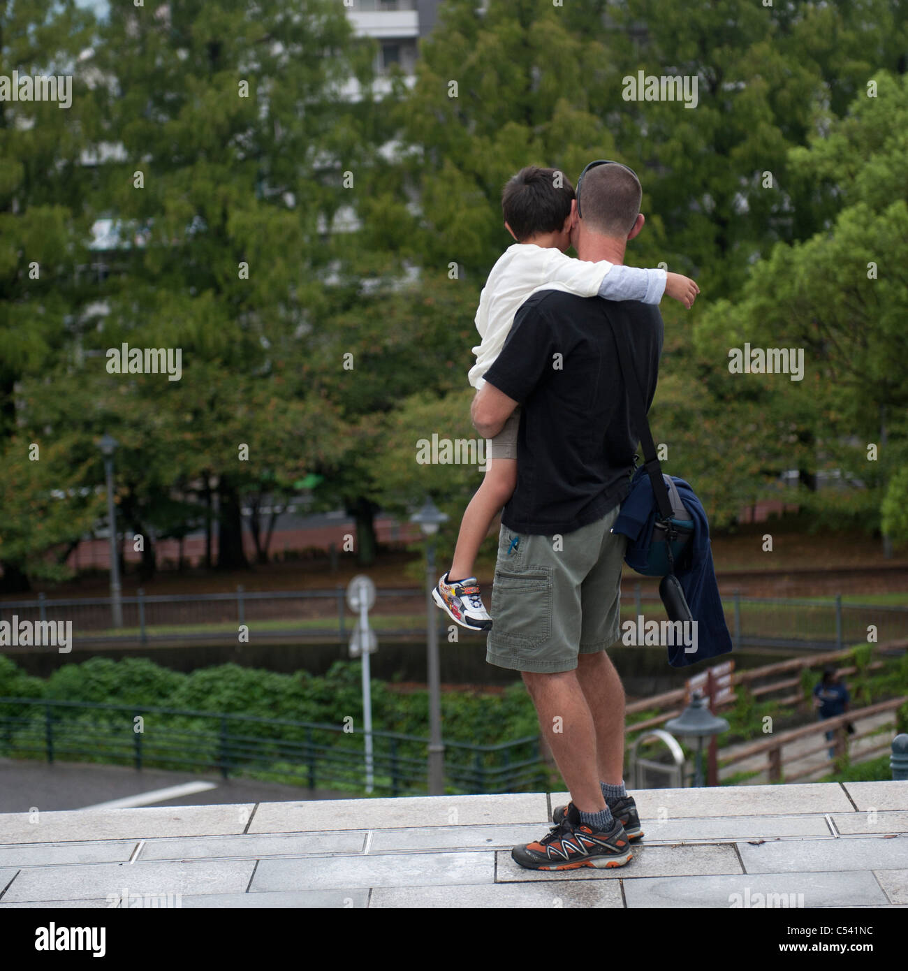 Man carrying his son in a park at Nagasaki Atomic Bomb Museum, Nagasaki ...