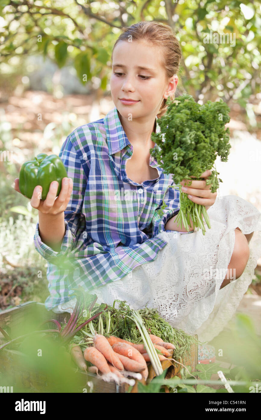 Girl choosing vegetables from a crate Stock Photo - Alamy