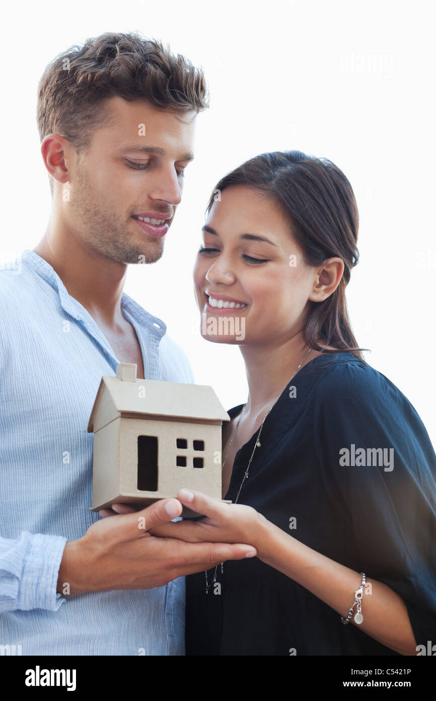 Cute young couple holding small model house Stock Photo - Alamy