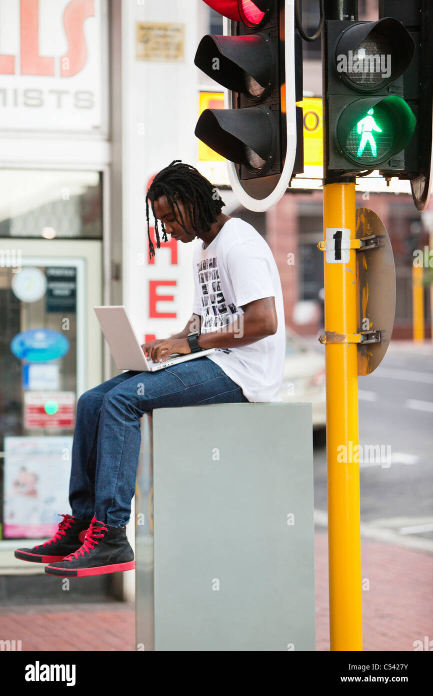 Man using a laptop near traffic light Stock Photo - Alamy