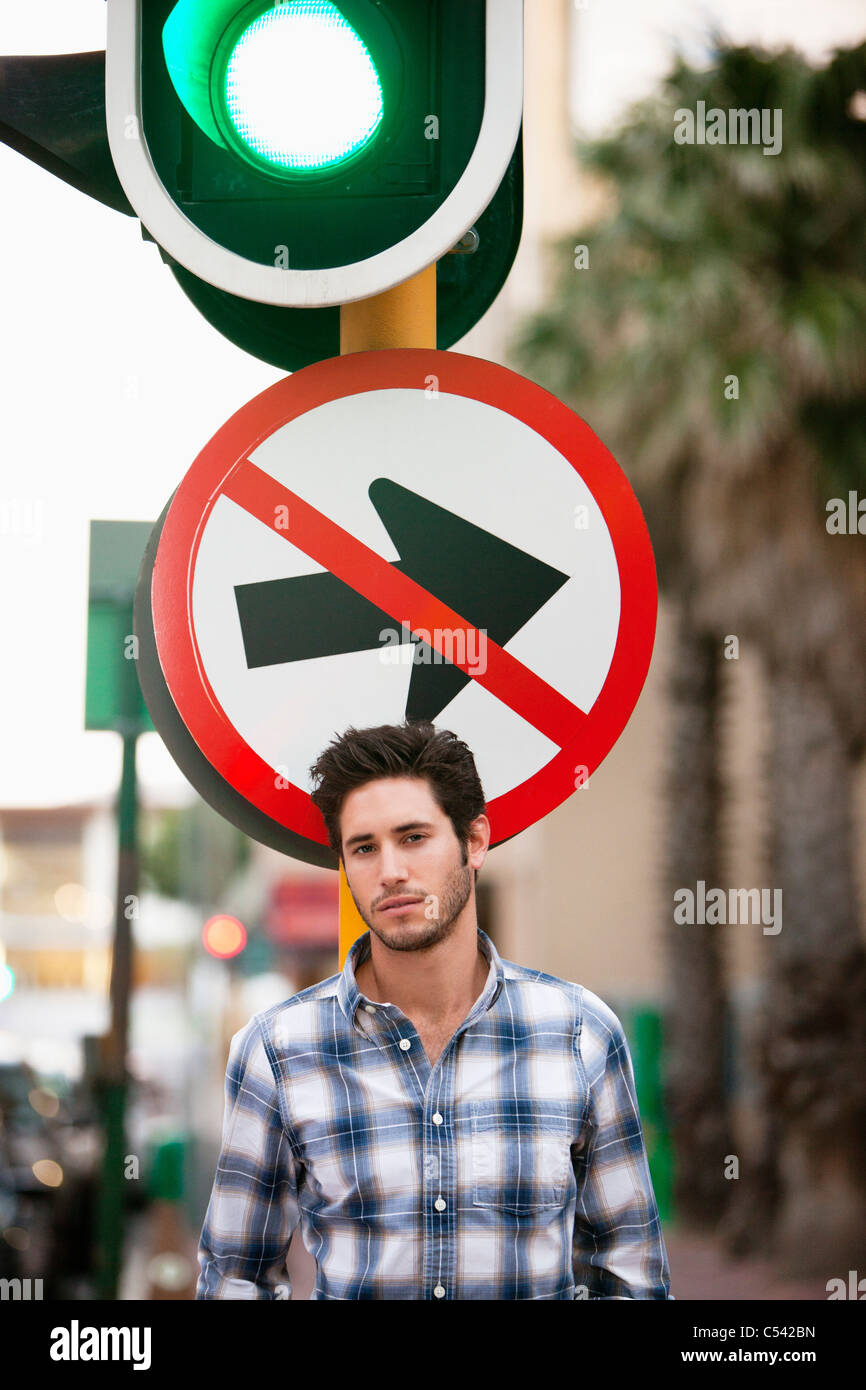 Man with "No Entry" sign and traffic light in the background Stock ...