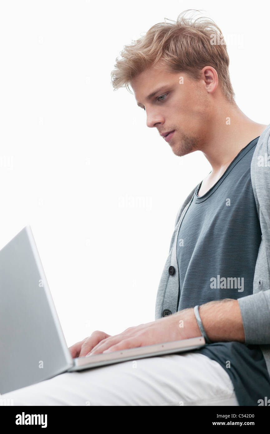 Young man using a laptop Stock Photo - Alamy