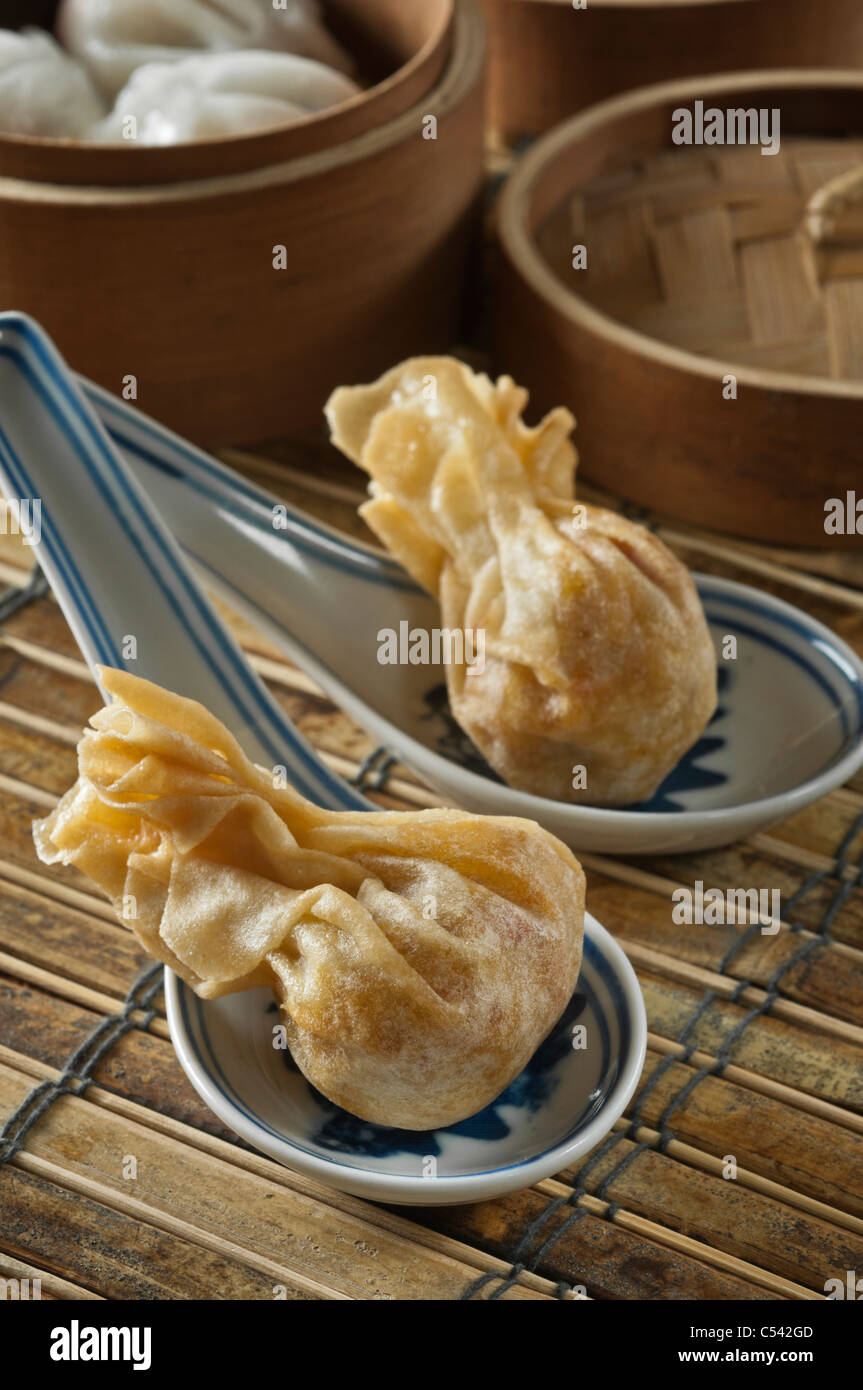 Won ton in Chinese spoons. Steamed dumplings in steamer basket Stock ...