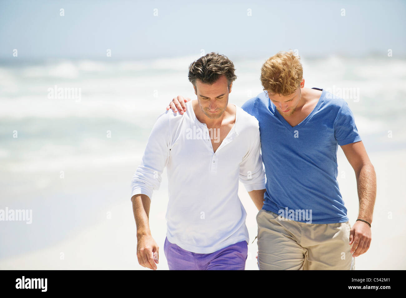 Two men walking on the beach Stock Photo - Alamy
