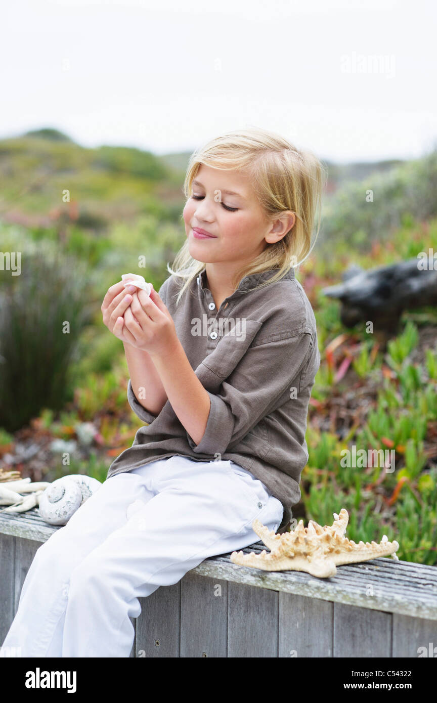 Girl playing with shells Stock Photo - Alamy