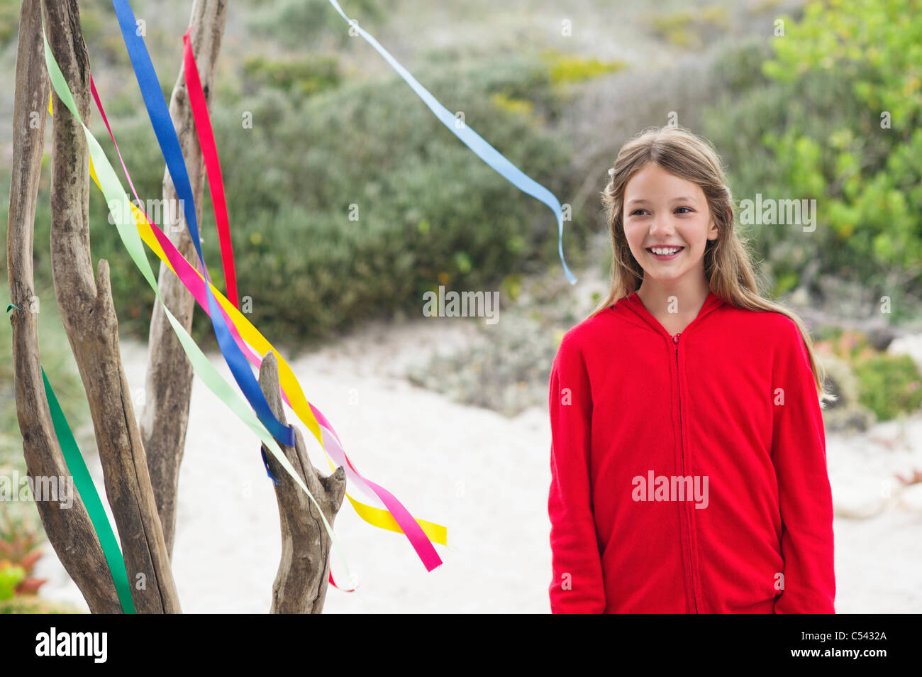 Girl standing near a tree and smiling Stock Photo - Alamy