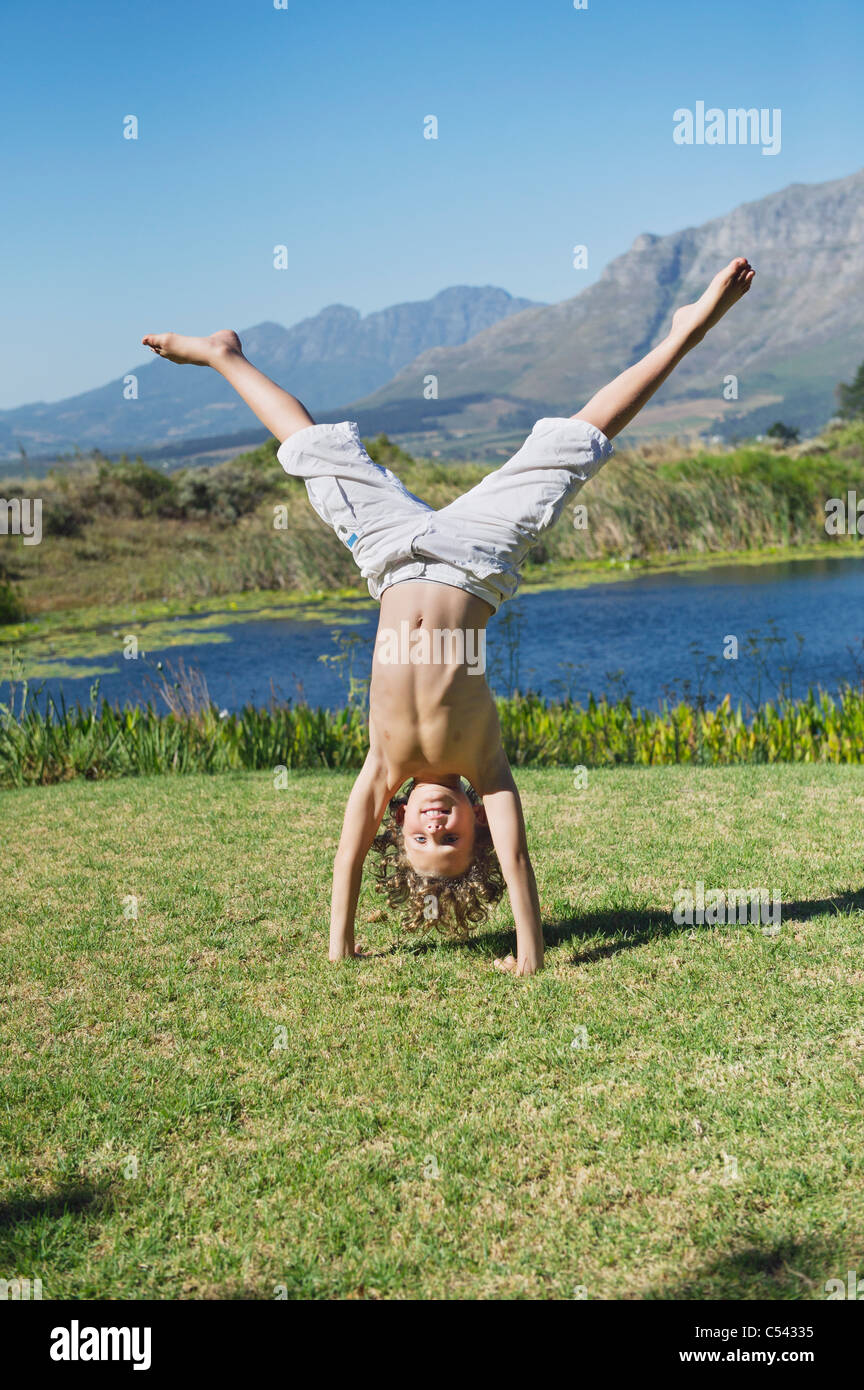 Cute little boy doing cartwheel against mountain Stock Photo - Alamy