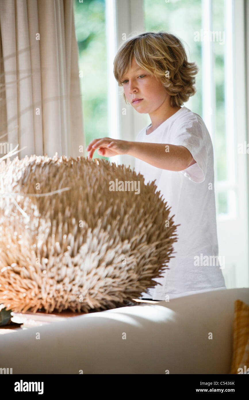 Boy touching a round shape object at home Stock Photo - Alamy