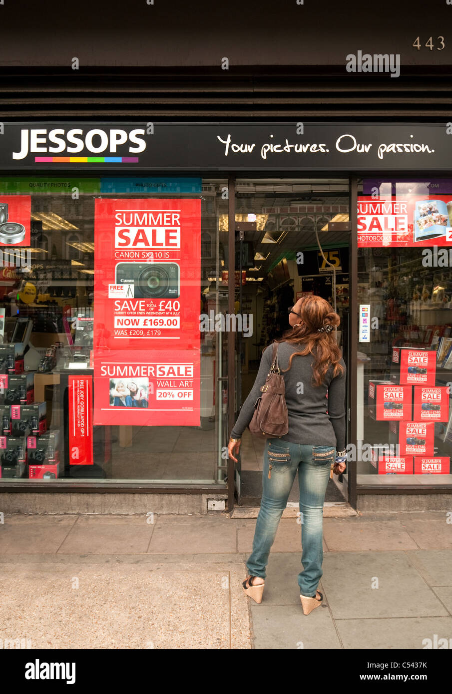 A woman looking at signs for a sale at Jessops Photographic store, the ...