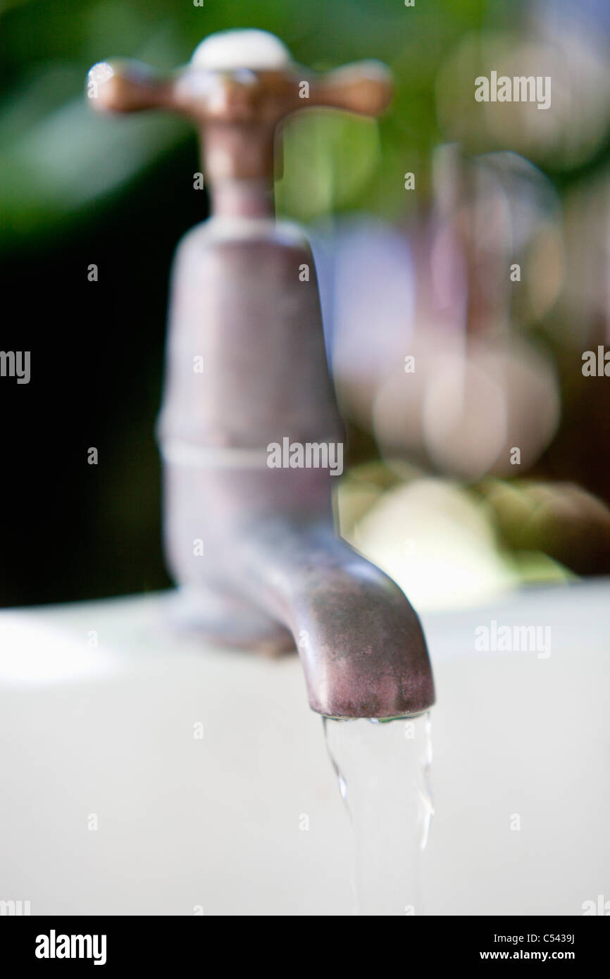 Close-up of running water from a brass faucet Stock Photo - Alamy