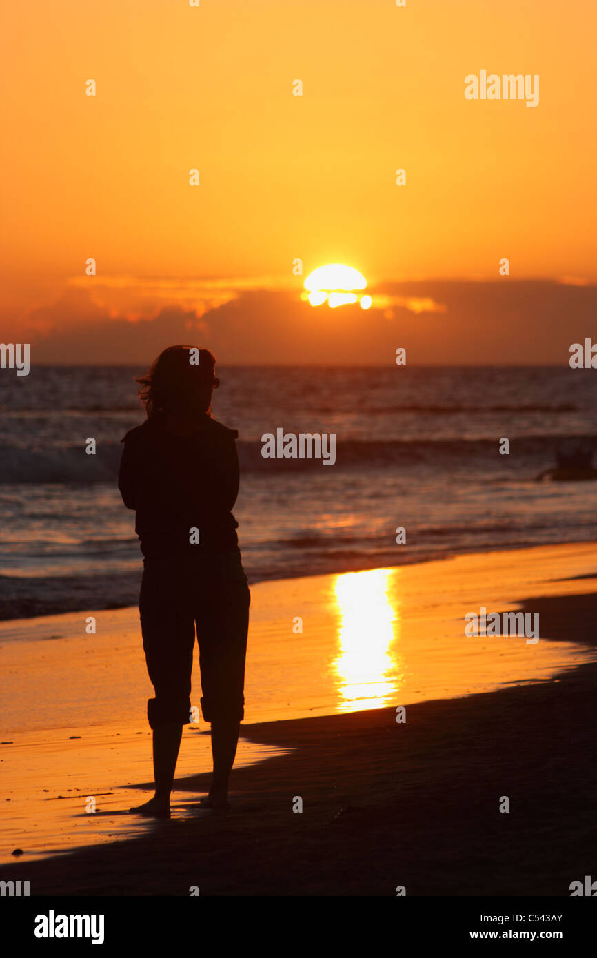 Woman on beach at sunset Stock Photo - Alamy
