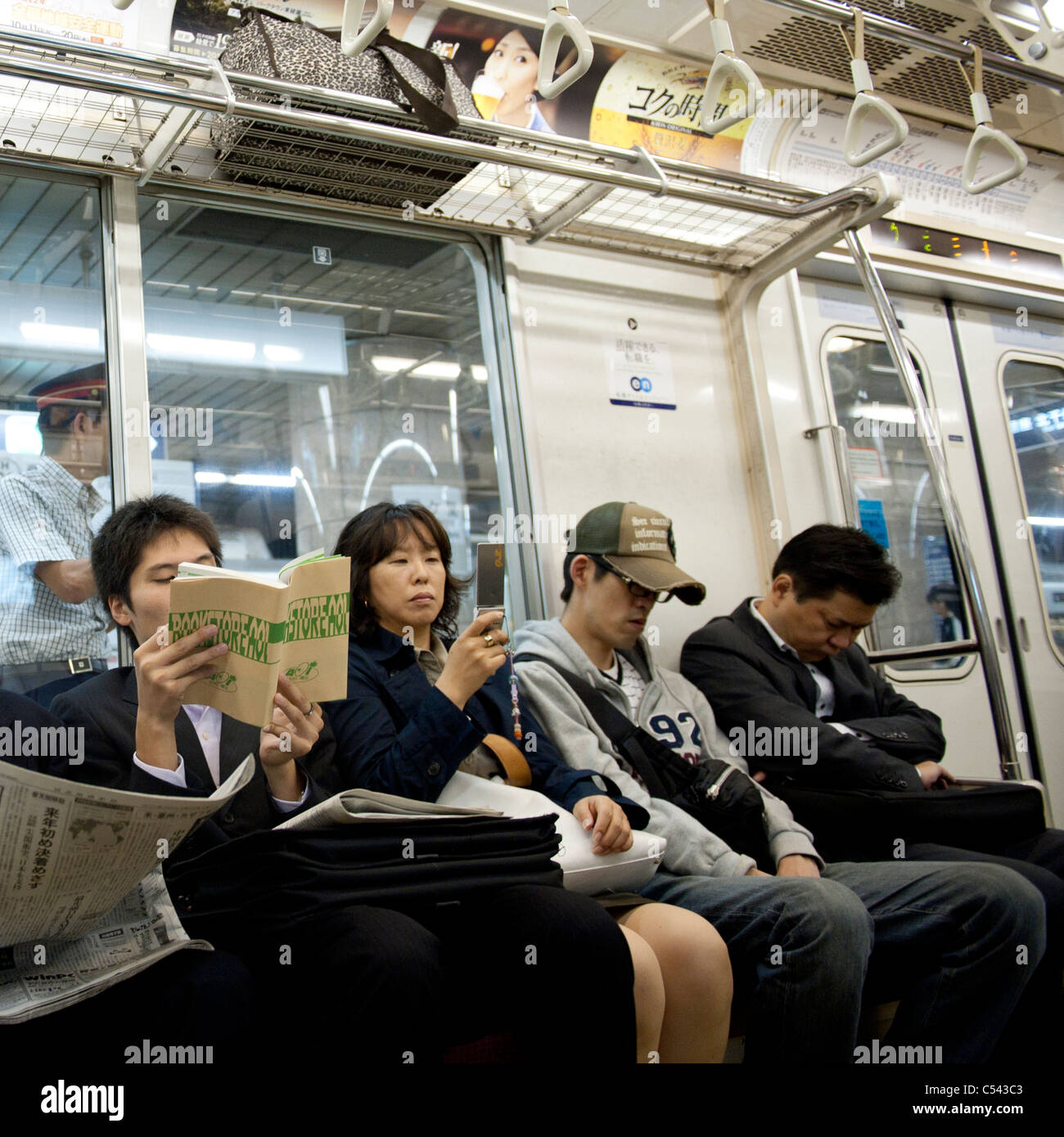 Tokyo metro passengers on phones hi-res stock photography and images ...