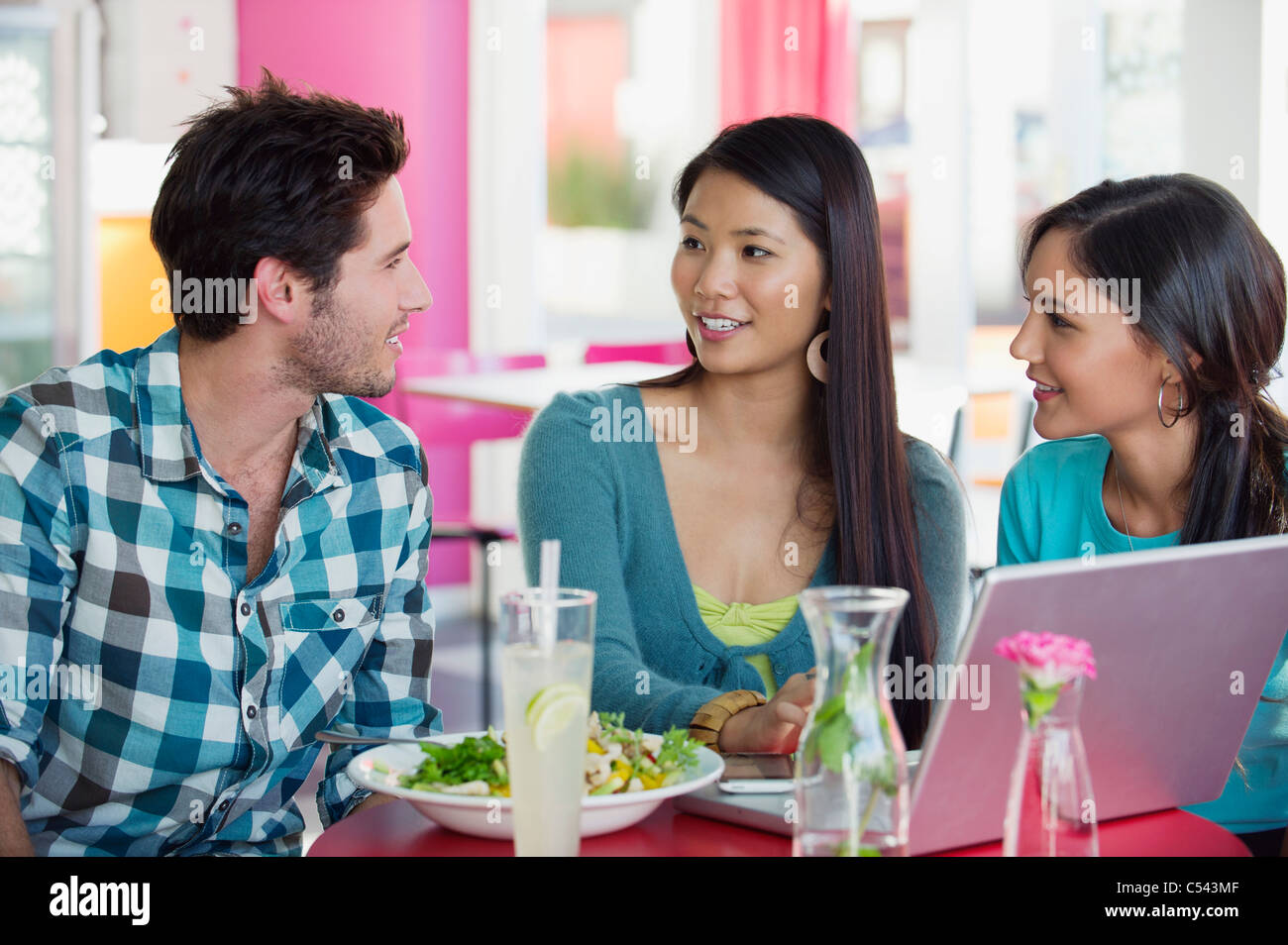 Friends looking at each other while eating food in a restaurant Stock ...