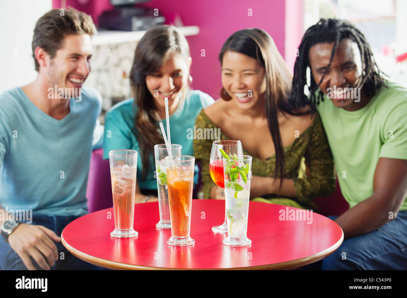 Friends sitting in a restaurant with focus on beverage Stock Photo - Alamy