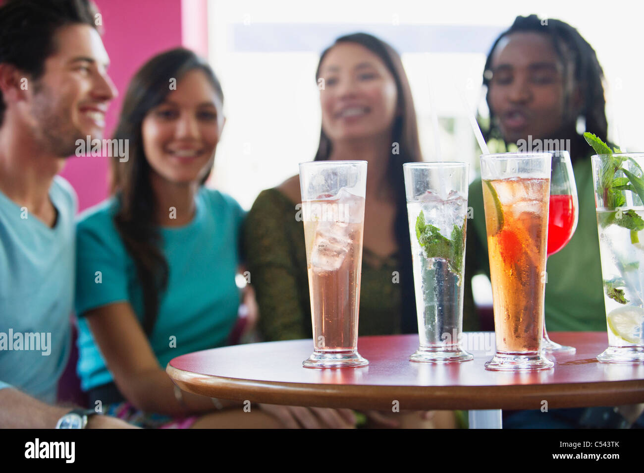 Friends sitting in a restaurant with focus on beverage Stock Photo - Alamy
