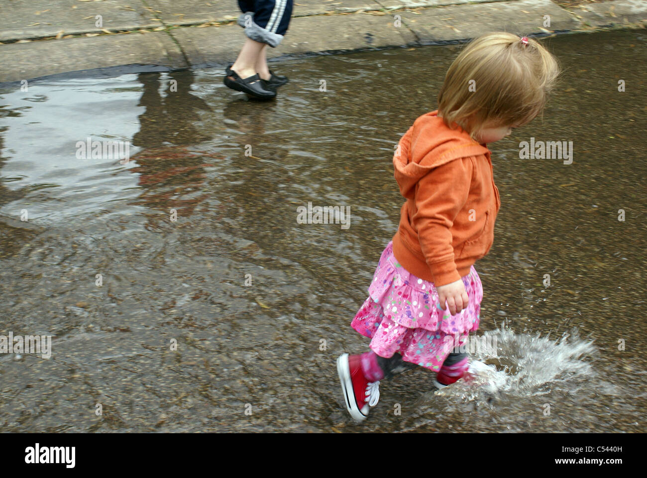 Toddler splashing in puddle Stock Photo - Alamy