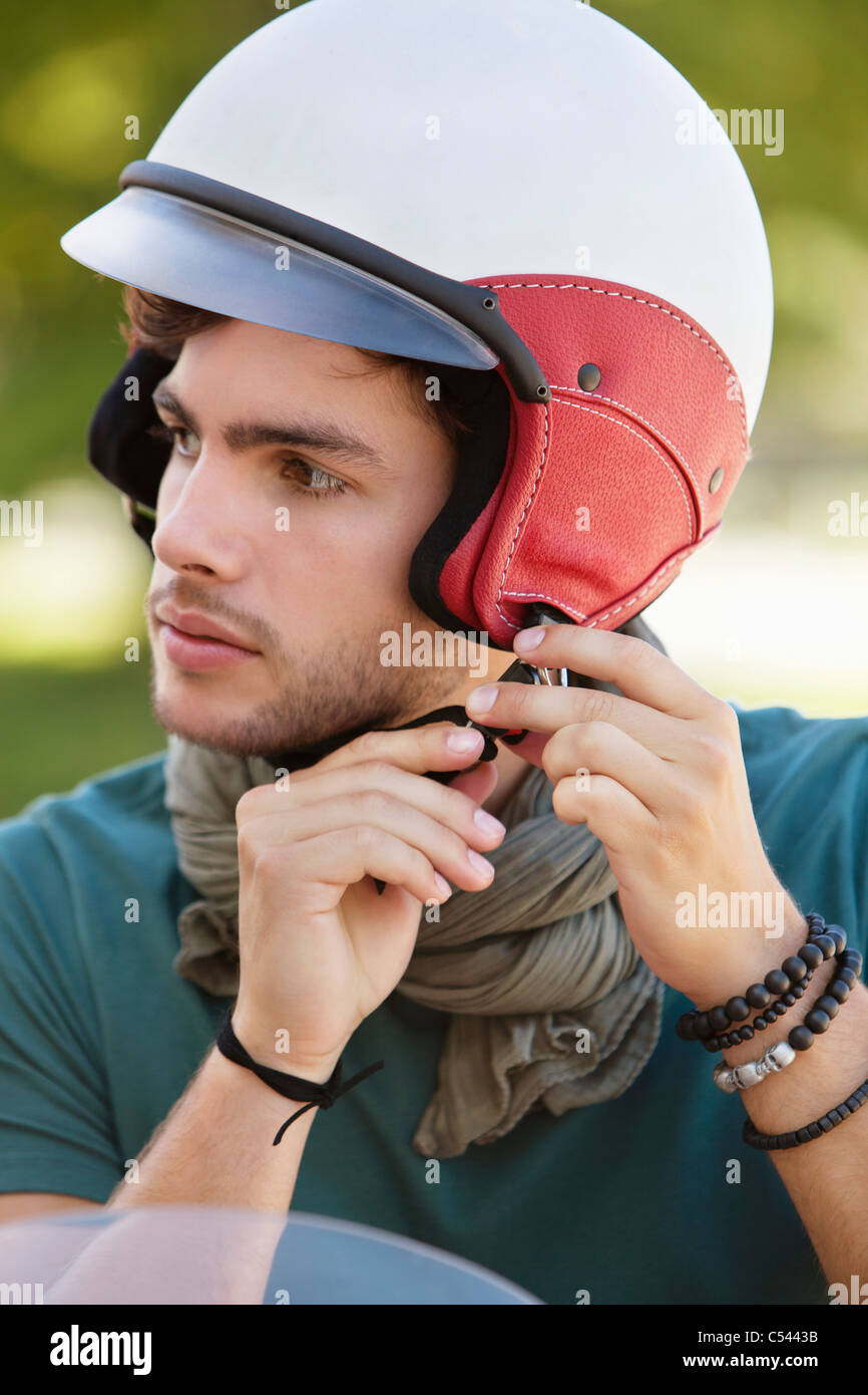 Close-up of a man adjusting his helmet Stock Photo - Alamy