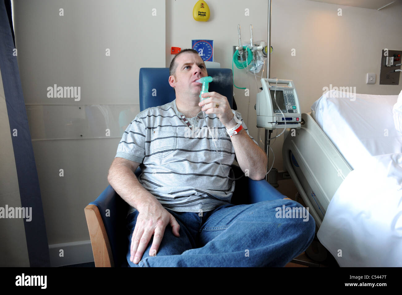 A man inhales on a nebuliser to help with his breathing in his room in ...