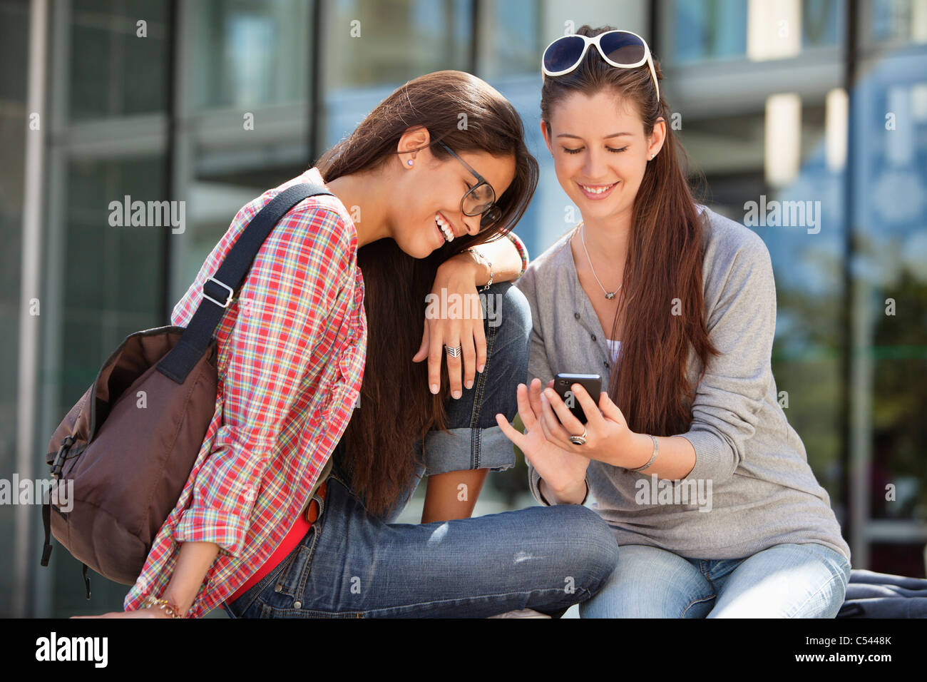 Female friends sending text message hi-res stock photography and images ...