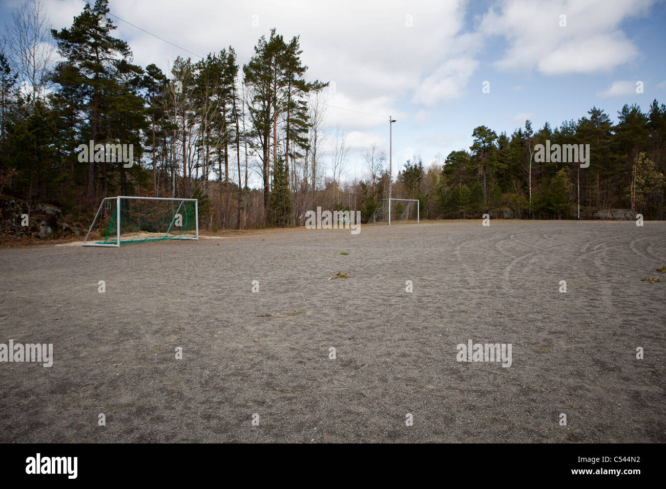 Football pitch and goal post surrounded by forest Stock Photo - Alamy