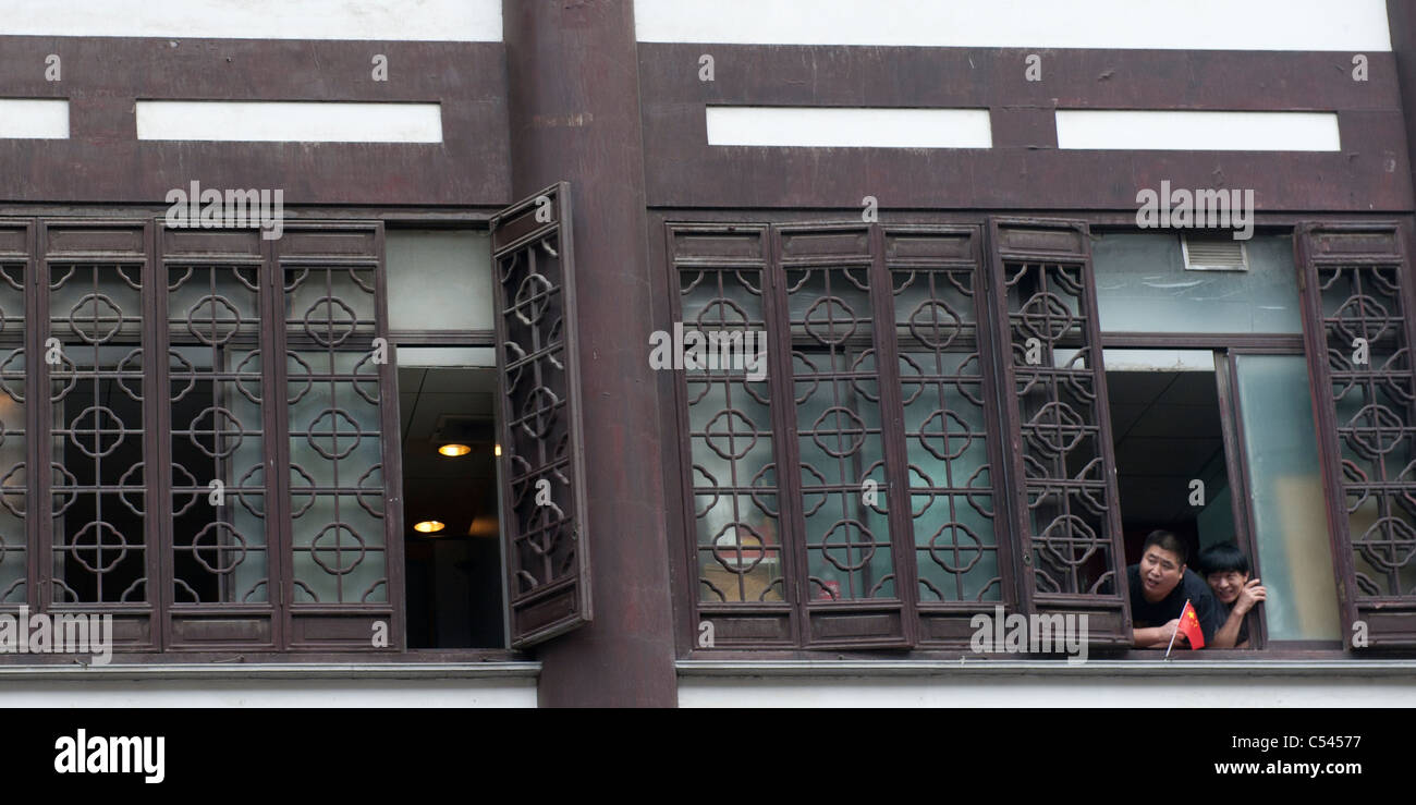 Two people leaning against a window, Shanghai, China Stock Photo - Alamy