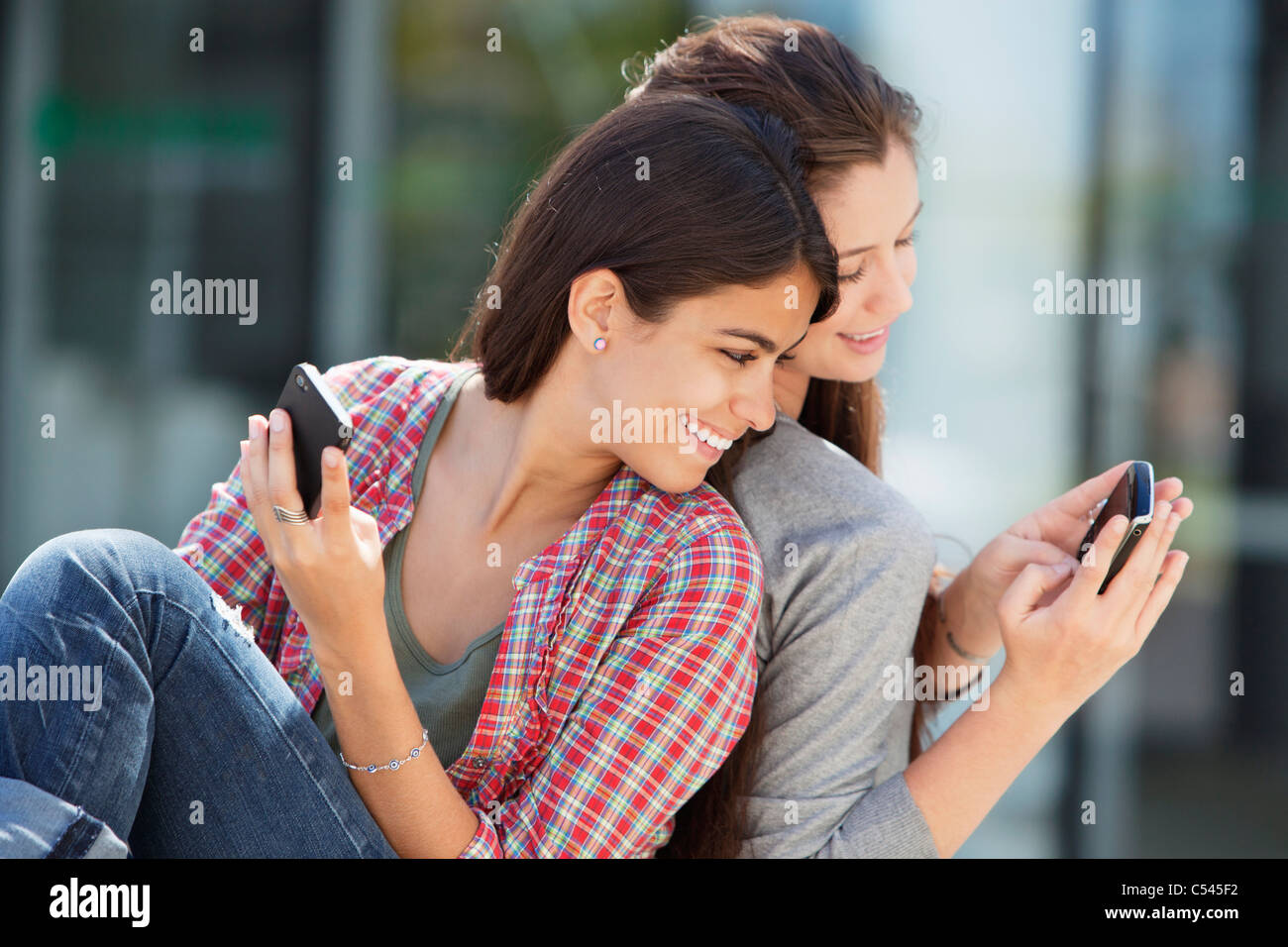 Young woman showing her message to her friend Stock Photo - Alamy