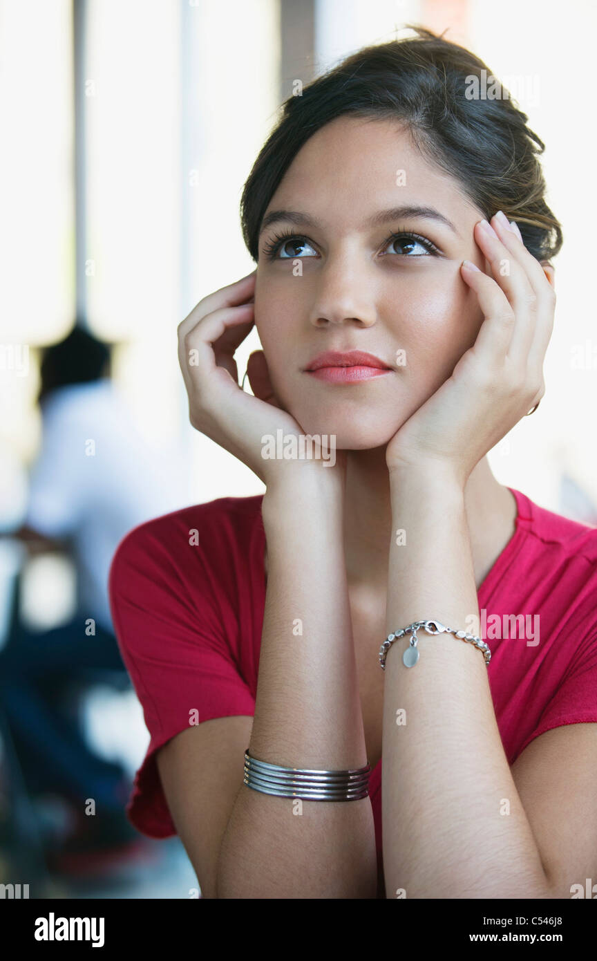 Contemplative woman looking up with head in hands Stock Photo - Alamy