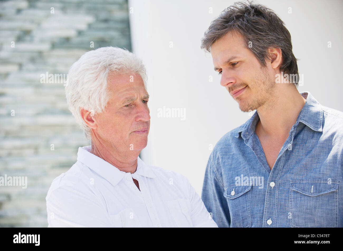 Mid adult man talking to his father Stock Photo - Alamy
