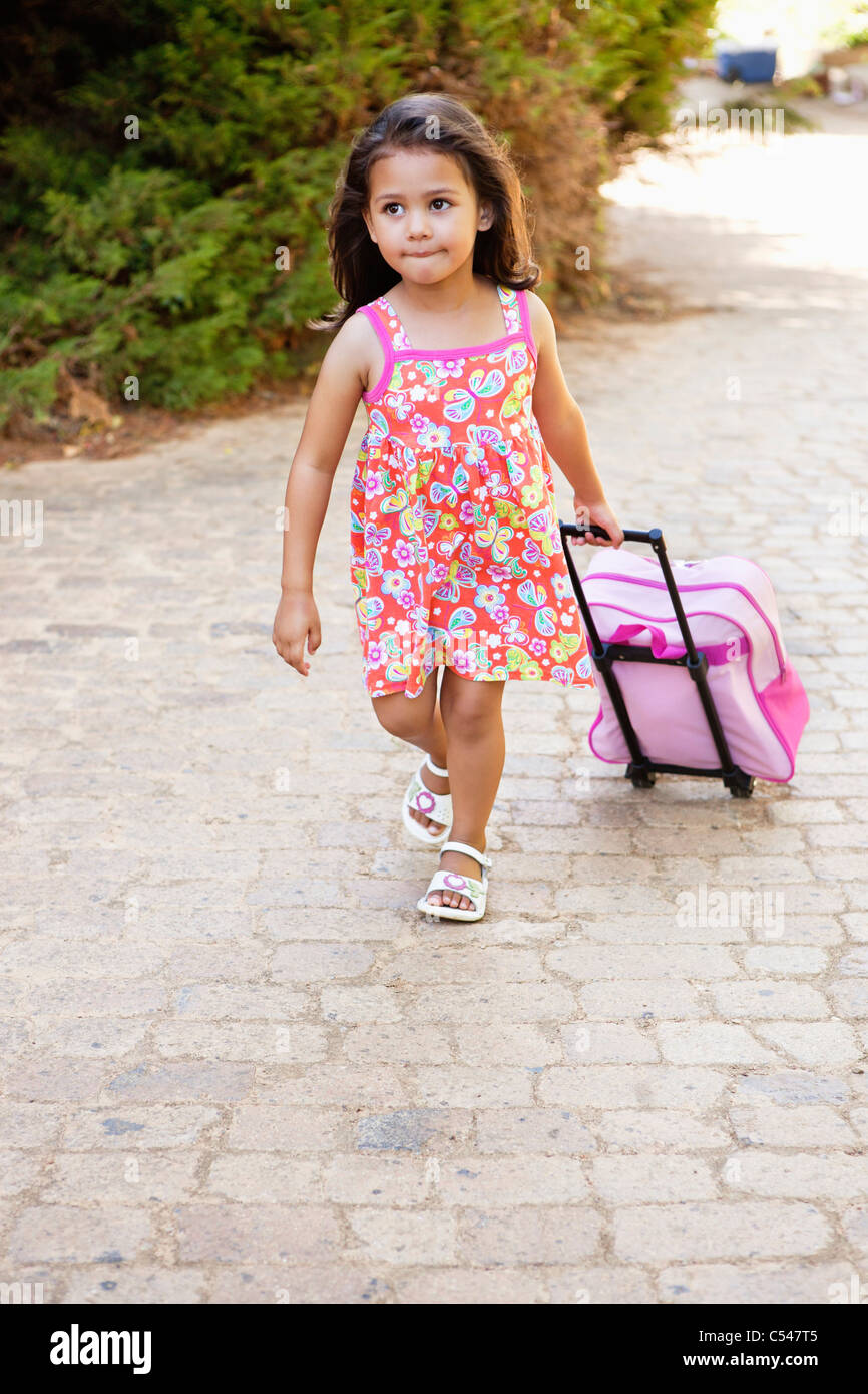 Little girl pulling a bag Stock Photo - Alamy