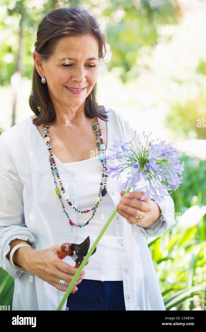 Smiling woman pruning a flower Stock Photo - Alamy