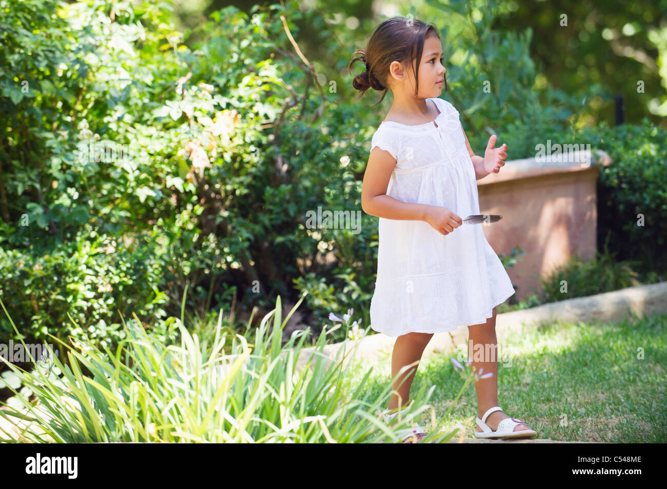 Side profile of a little girl walking in the garden Stock Photo - Alamy