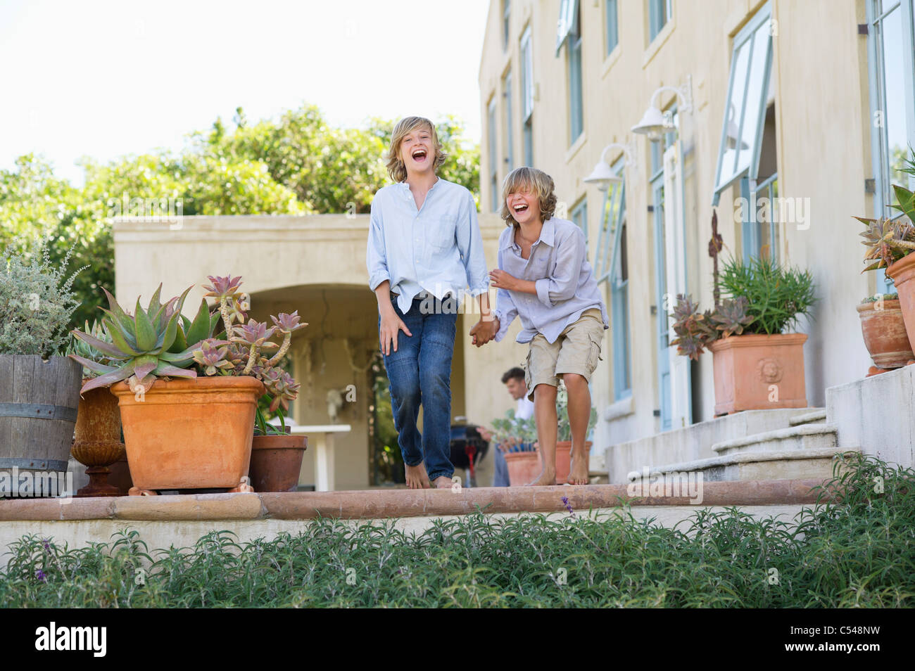 Two little children laughing outside house Stock Photo - Alamy