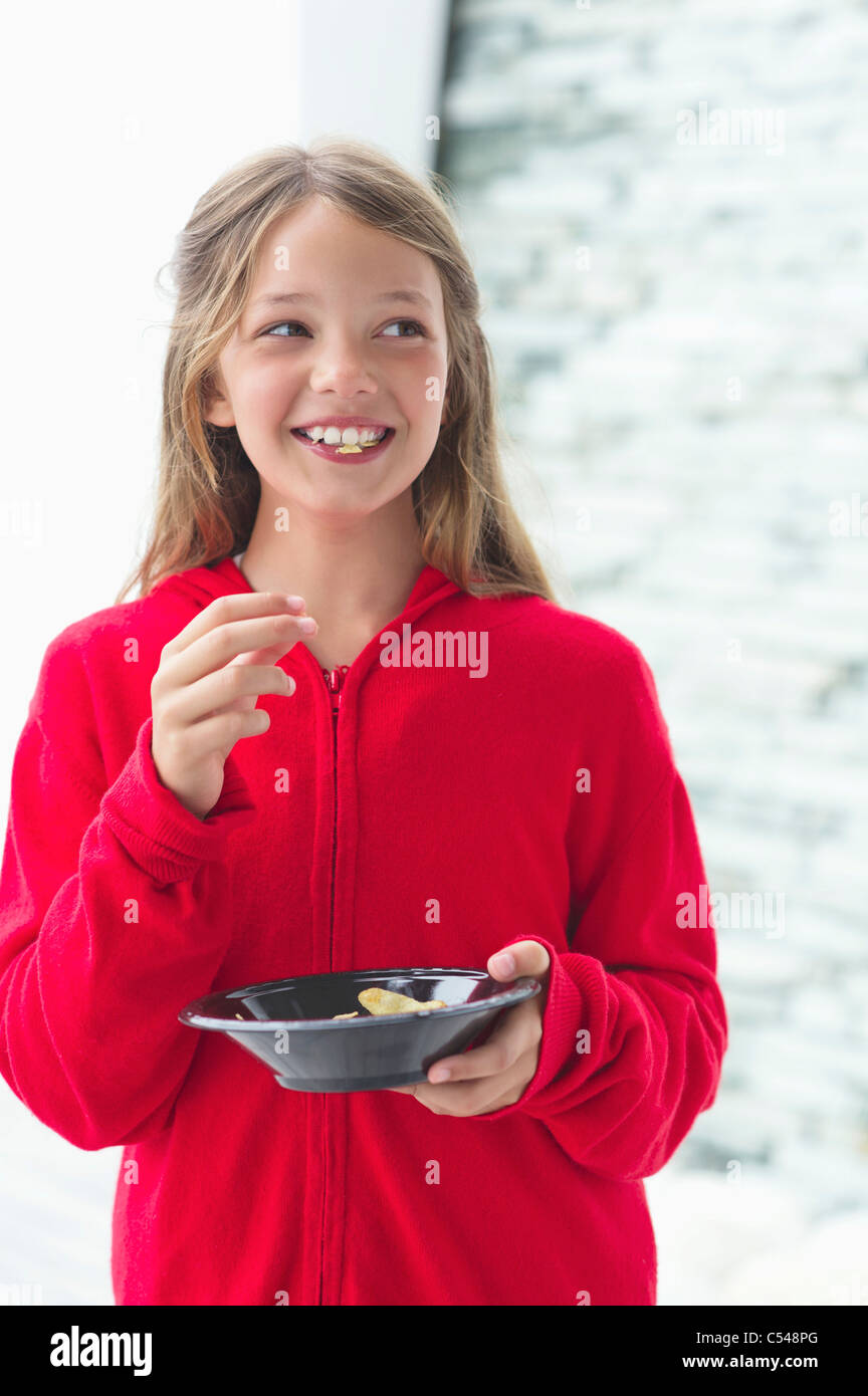 Smiling girl eating food Stock Photo - Alamy