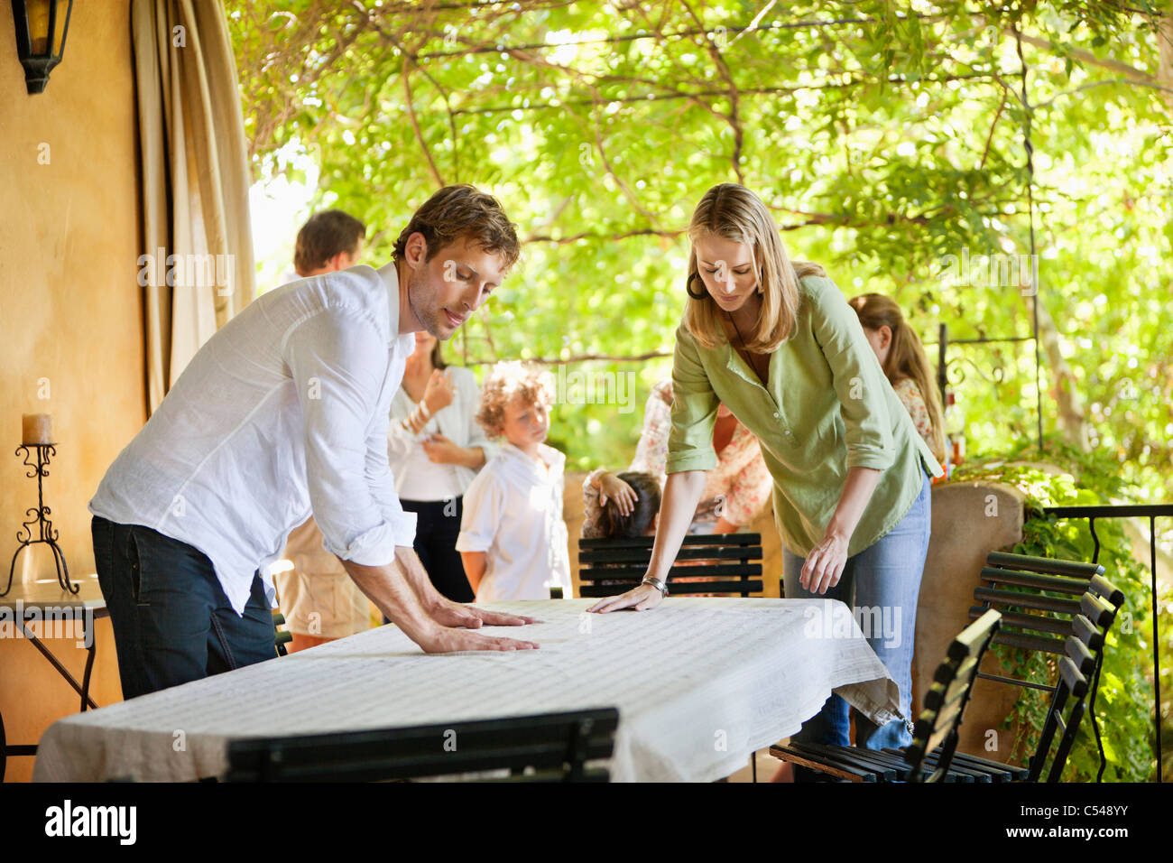 Couple preparing dining table for meal time Stock Photo - Alamy