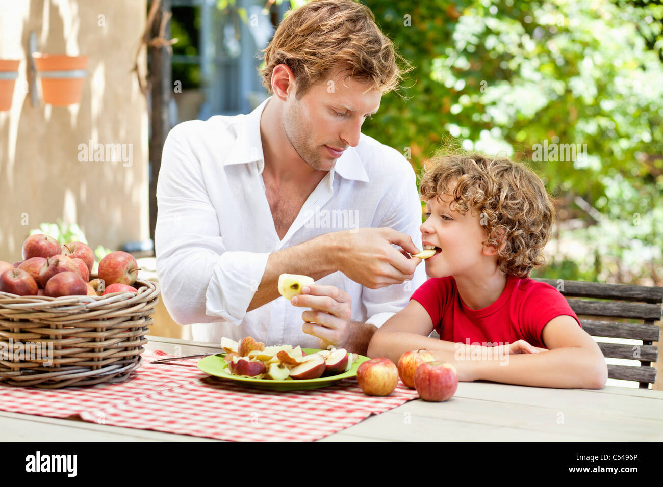 Father feeding apples to his son Stock Photo - Alamy