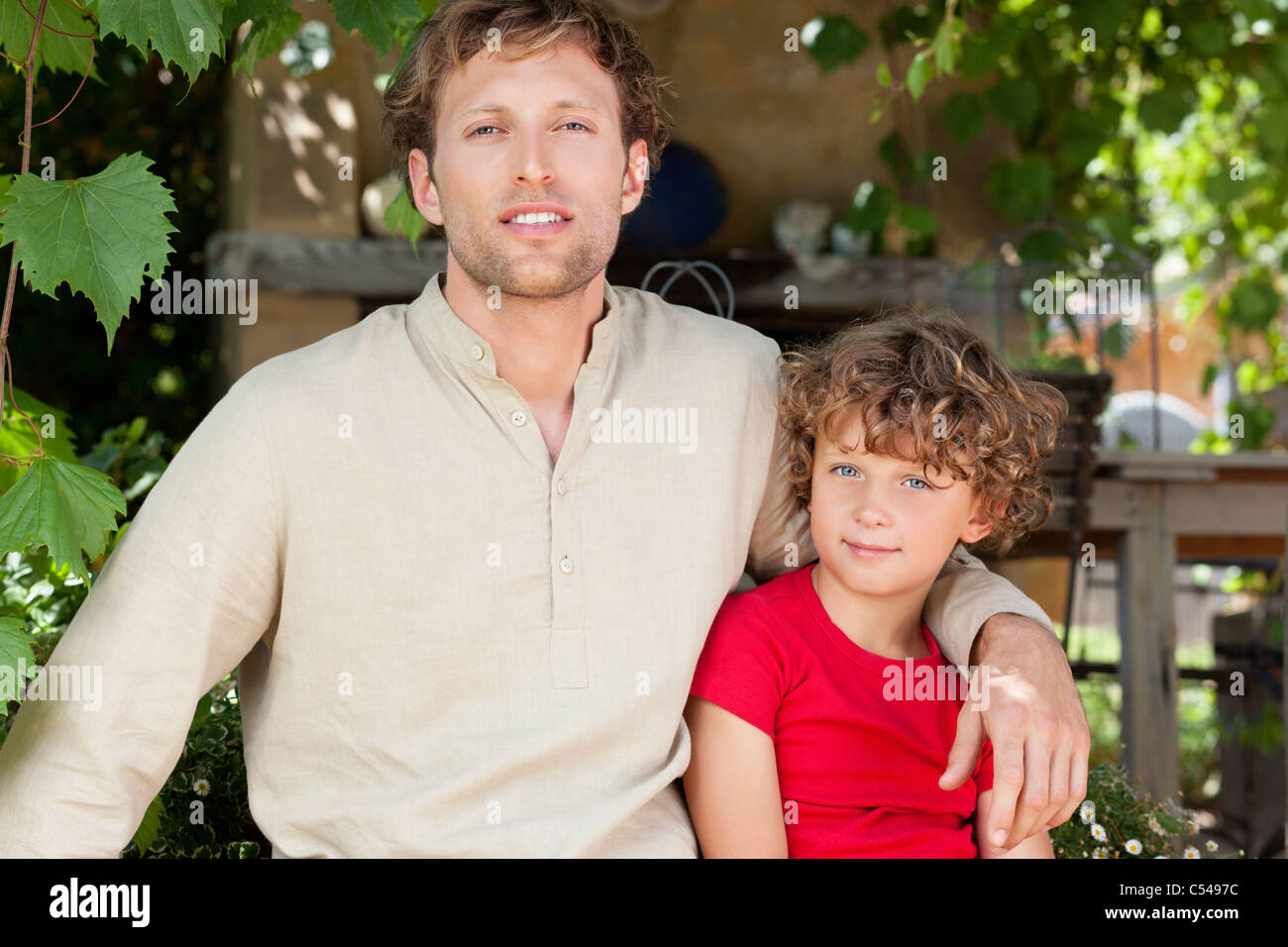 Portrait of a father and son with arm around Stock Photo - Alamy