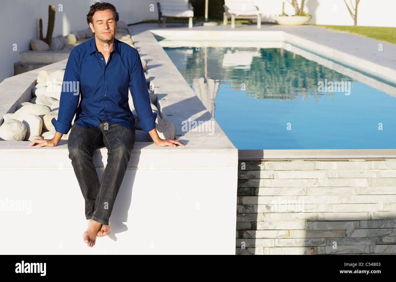 Man Sitting By Swimming Pool High Resolution Stock Photography and ...