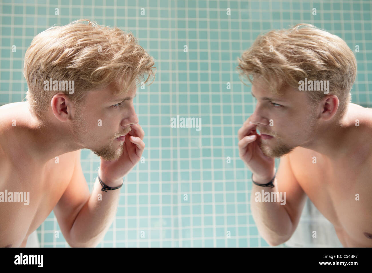 Man looking at himself in mirror Stock Photo - Alamy