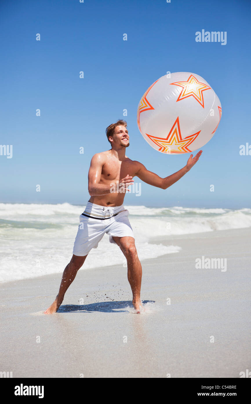 Man playing with beach ball Stock Photo - Alamy