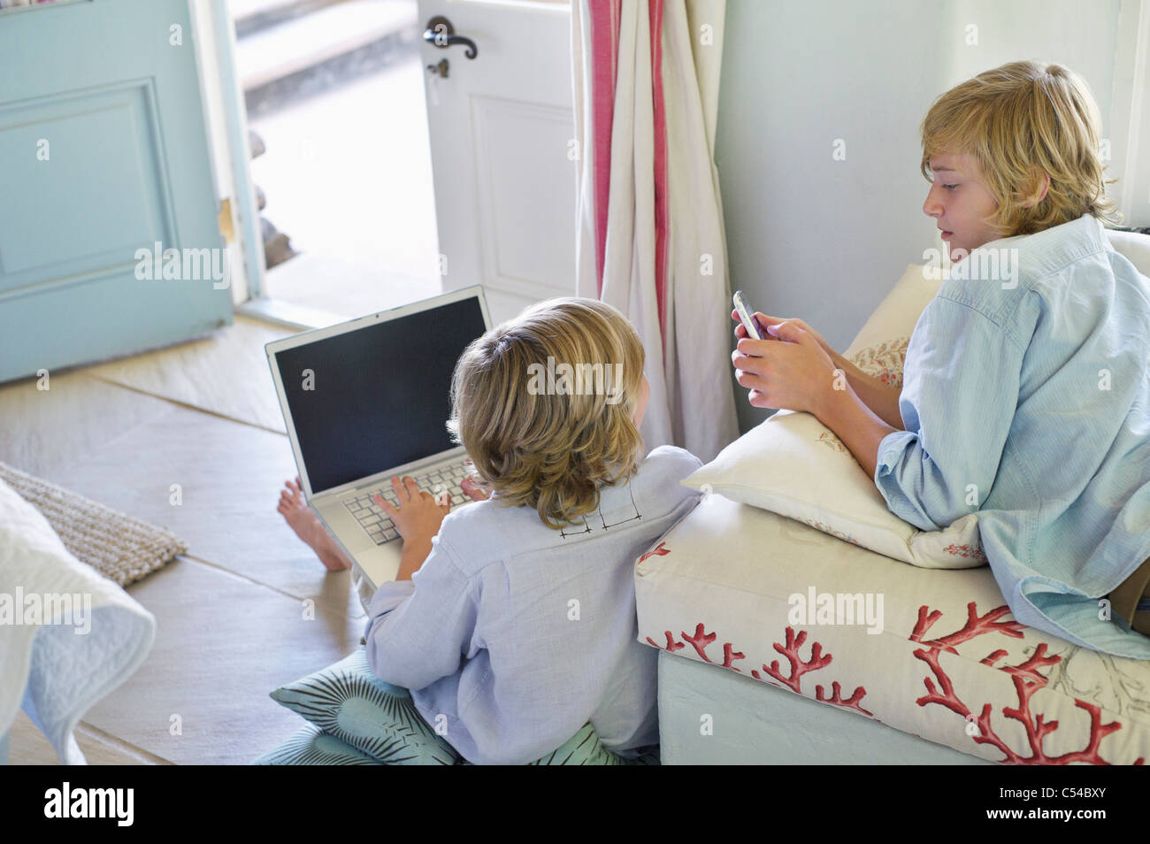 Children using electronic gadgets at home Stock Photo - Alamy