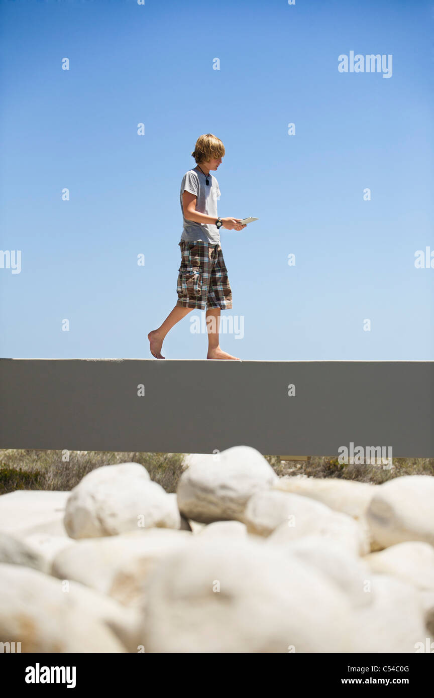 Teenage boy walking on the edge of a terrace Stock Photo - Alamy