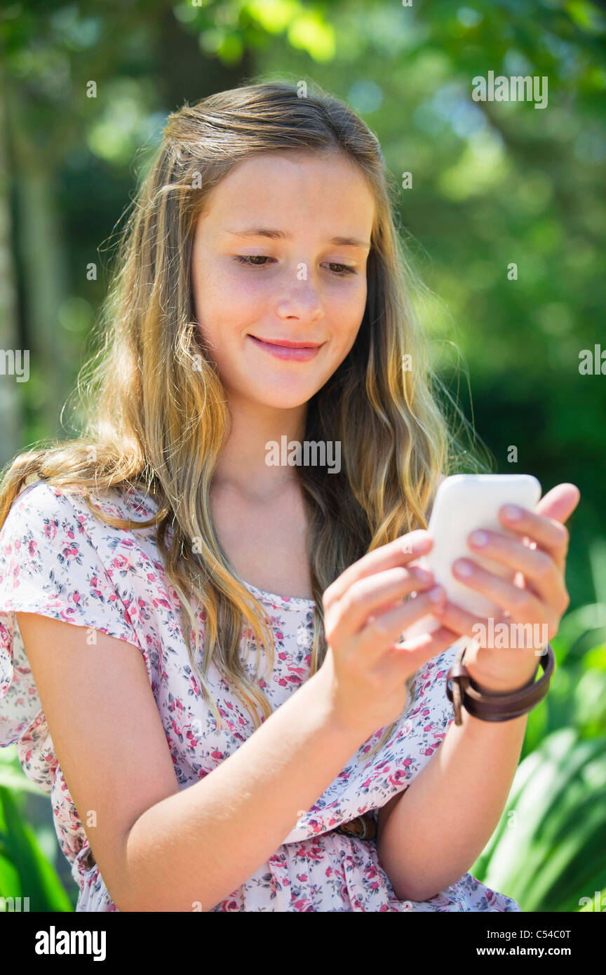 Smiling little girl text messaging using a mobile phone Stock Photo - Alamy