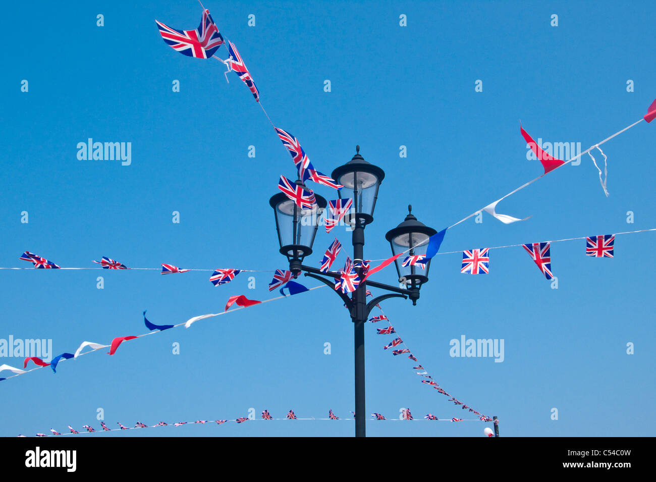 Strings of union flags against a blue sky Stock Photo - Alamy